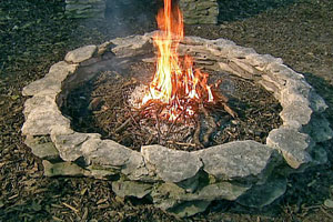 What should you circle a fire pit with to contain the fire?